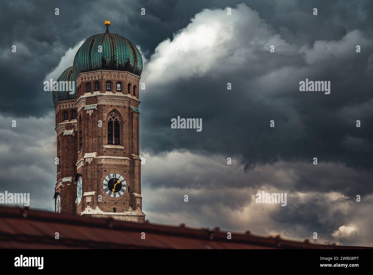 A majestic clock tower stands against a cloudy sky, with looming dark ...