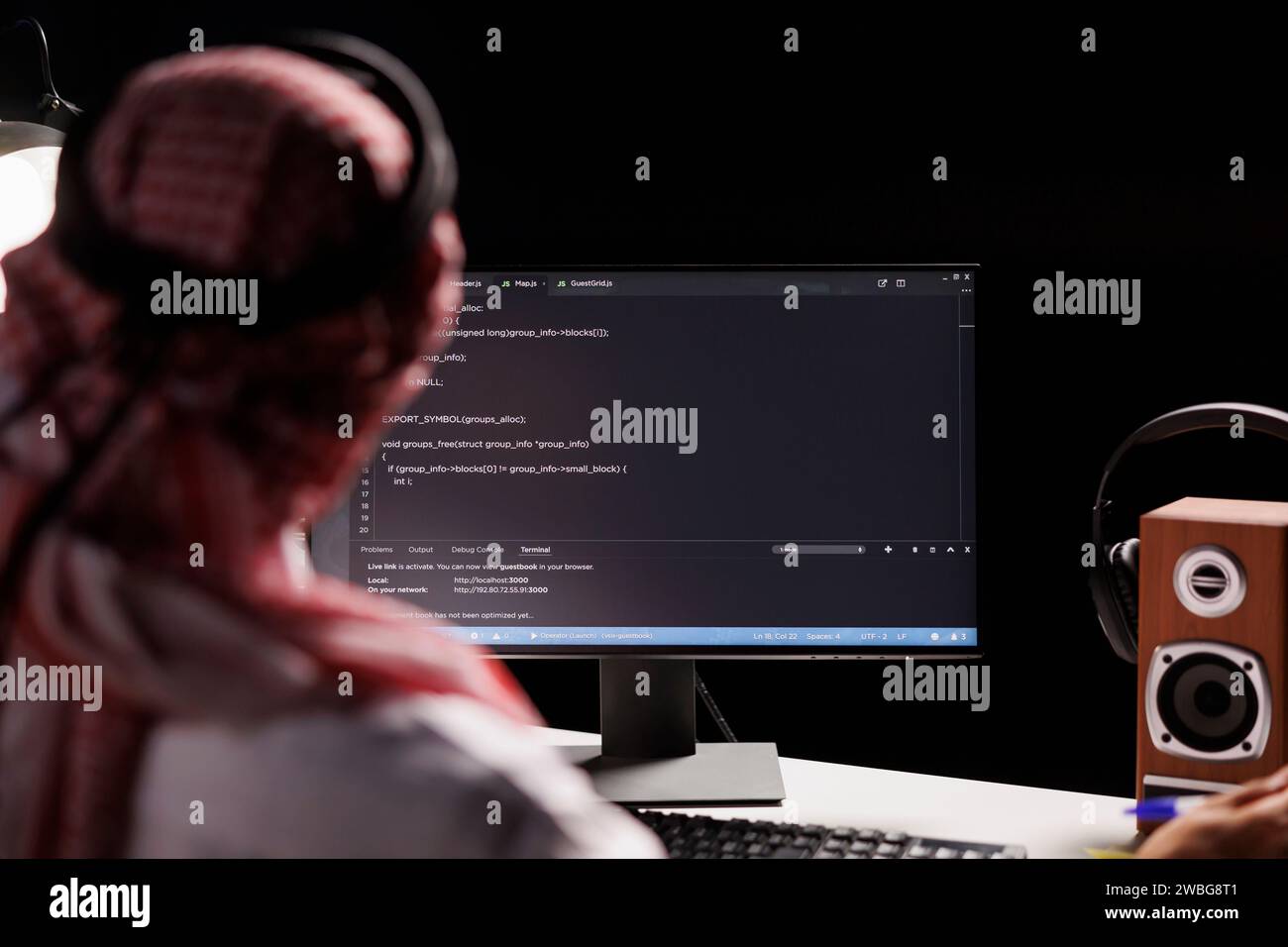 Muslim man sits at a computer and programs, exhibiting the app ...
