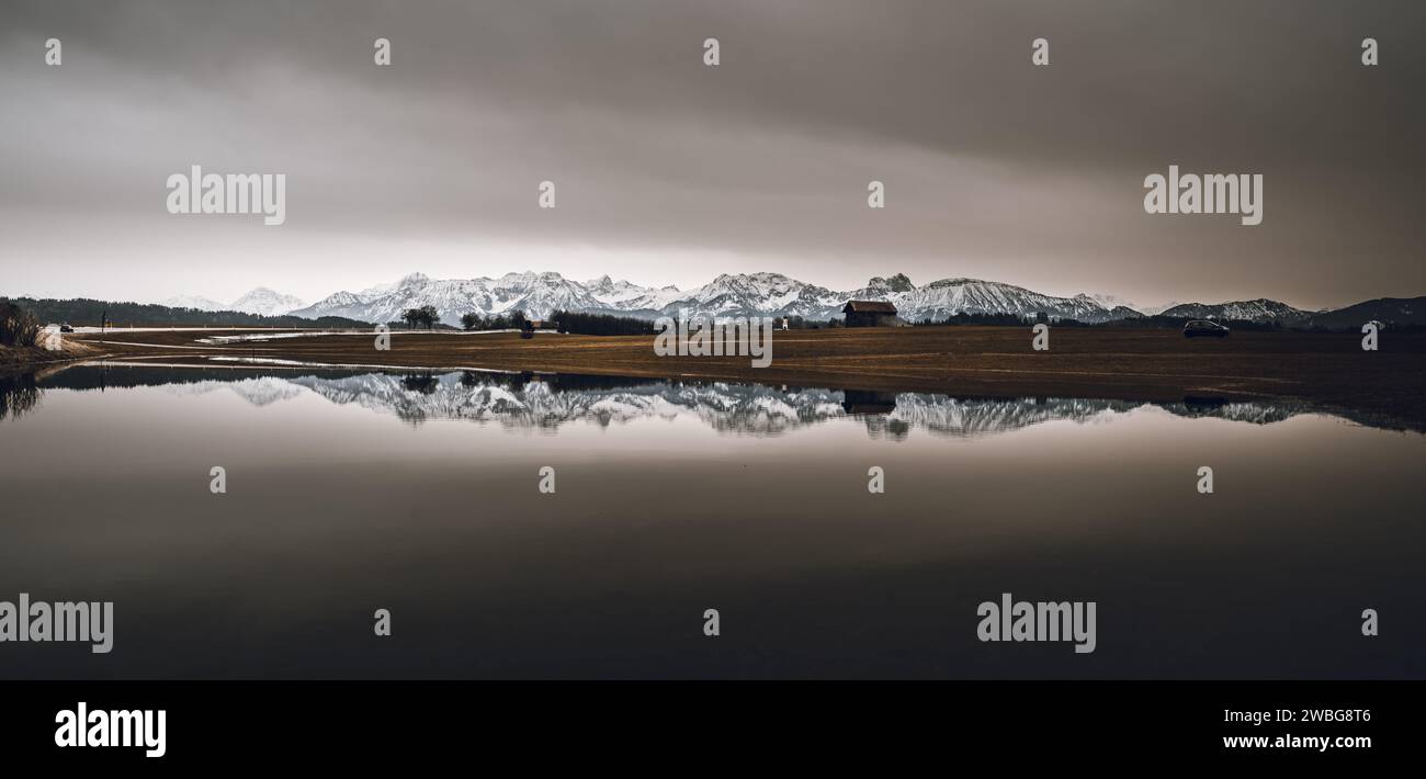 This image features two rustic barns in a serene rural landscape ...