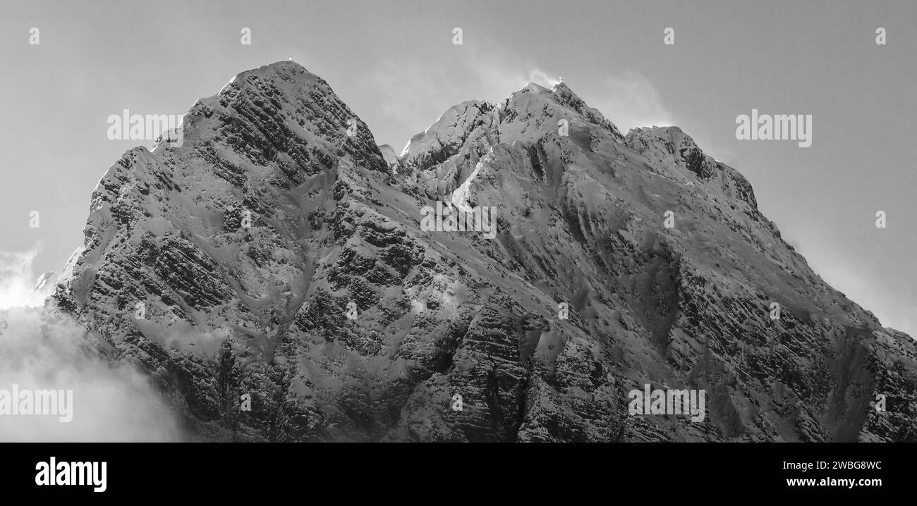 A stunning mountain vista featuring a snow-capped peak rising high into ...