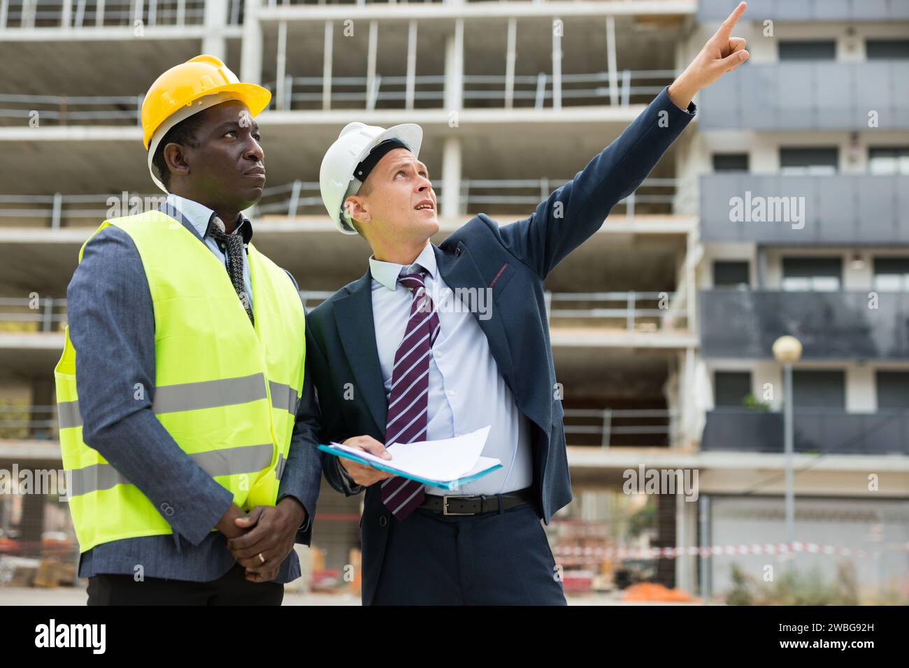 Positive architect and contractor having brief meeting on construction ...