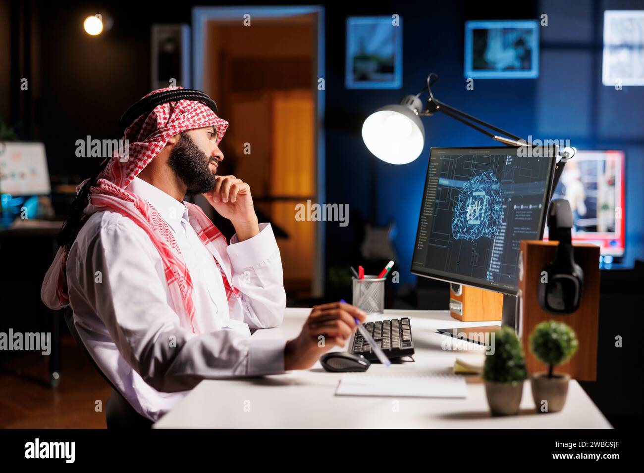 Middle Eastern professional in Arabic attire works at monitoring a ...