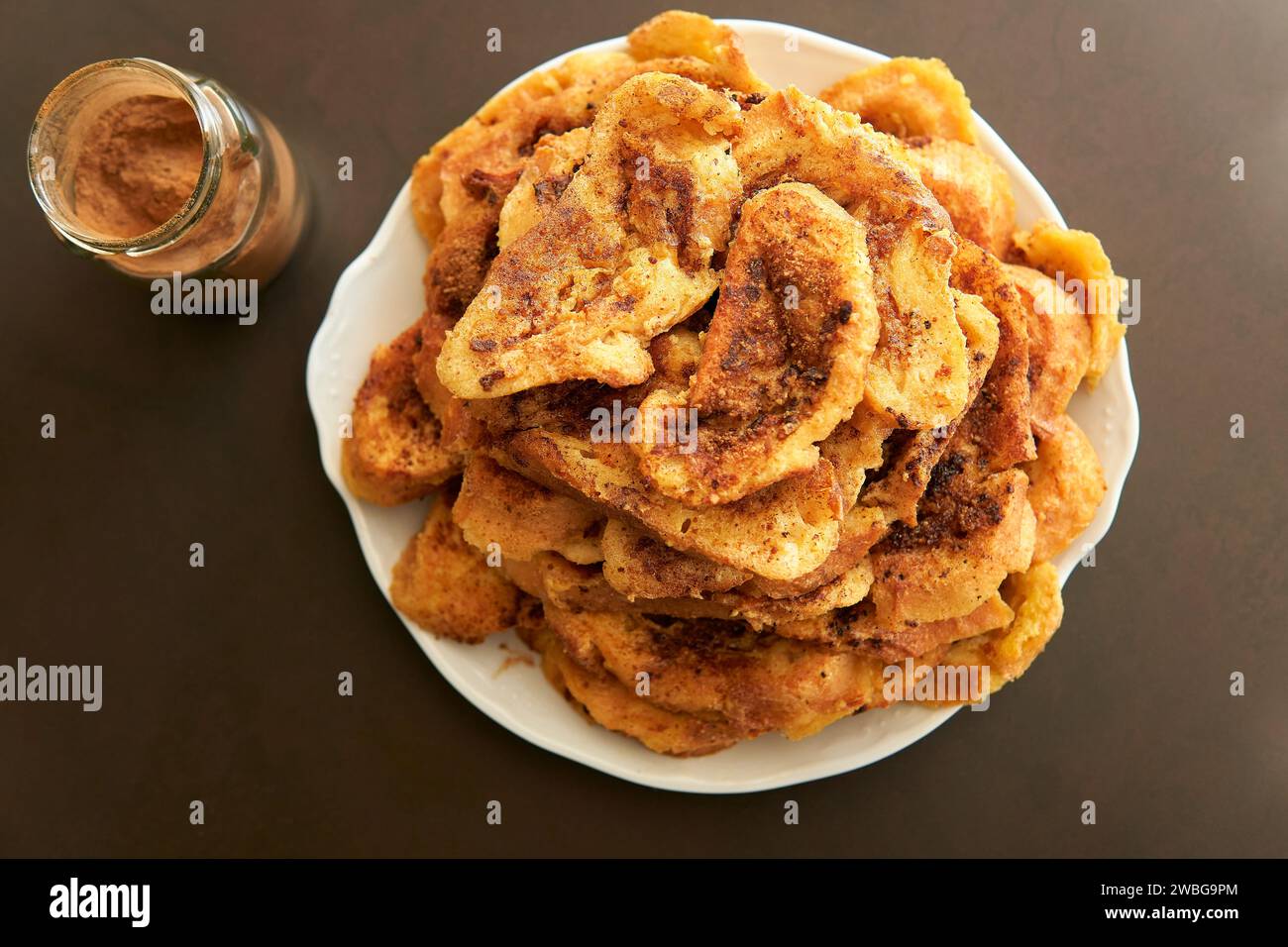 Flat lay of a stack of torrijas and cinnamon powder on the kitchen ...