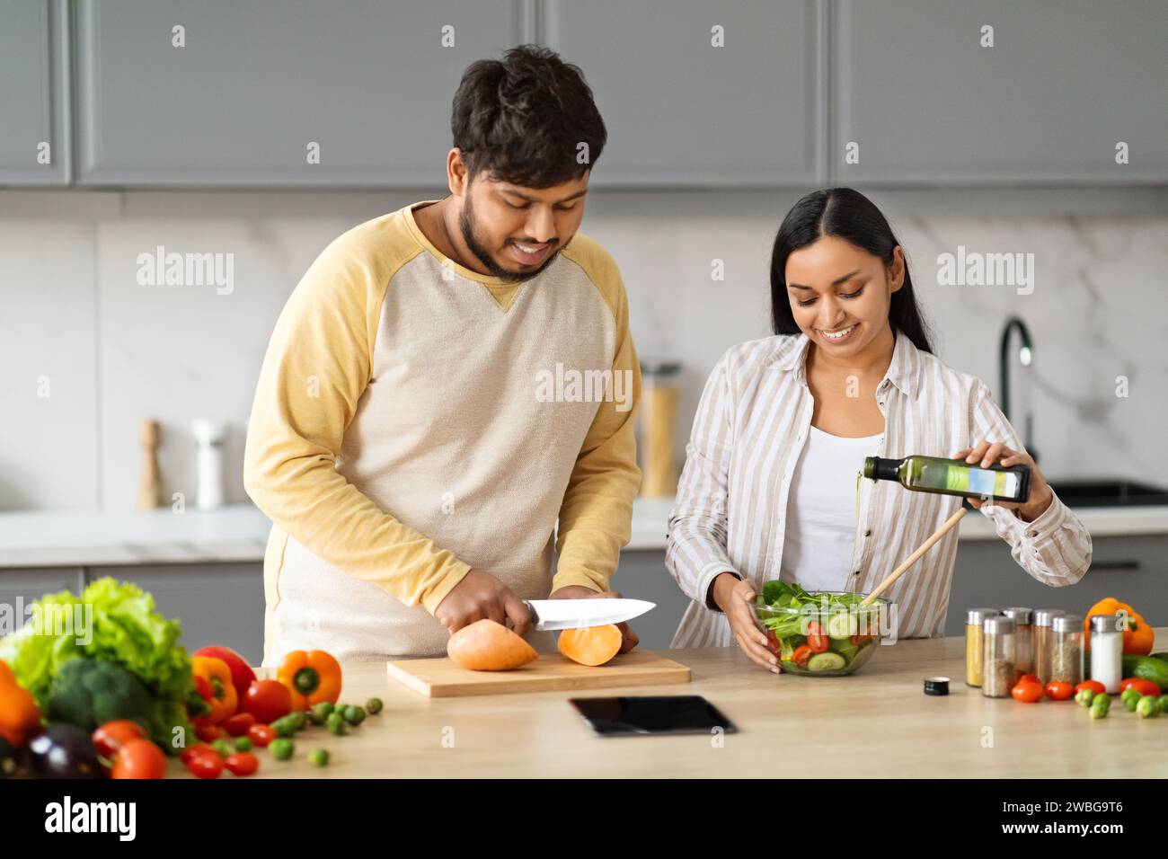 Cute millennial eastern couple preparing healthy dinner together Stock ...