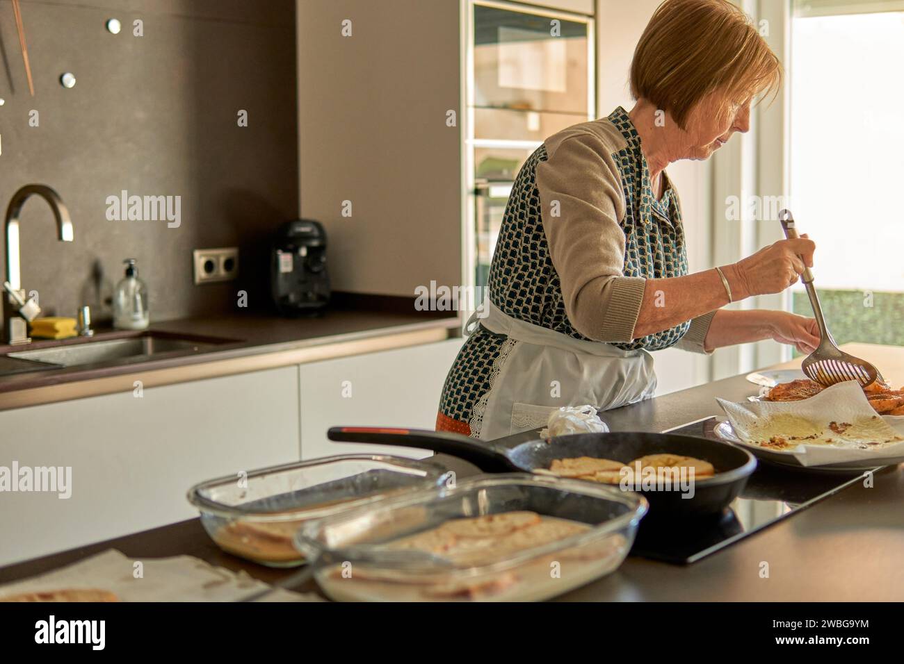 Elderly woman cooking torrijas for her family during Holy Week ...