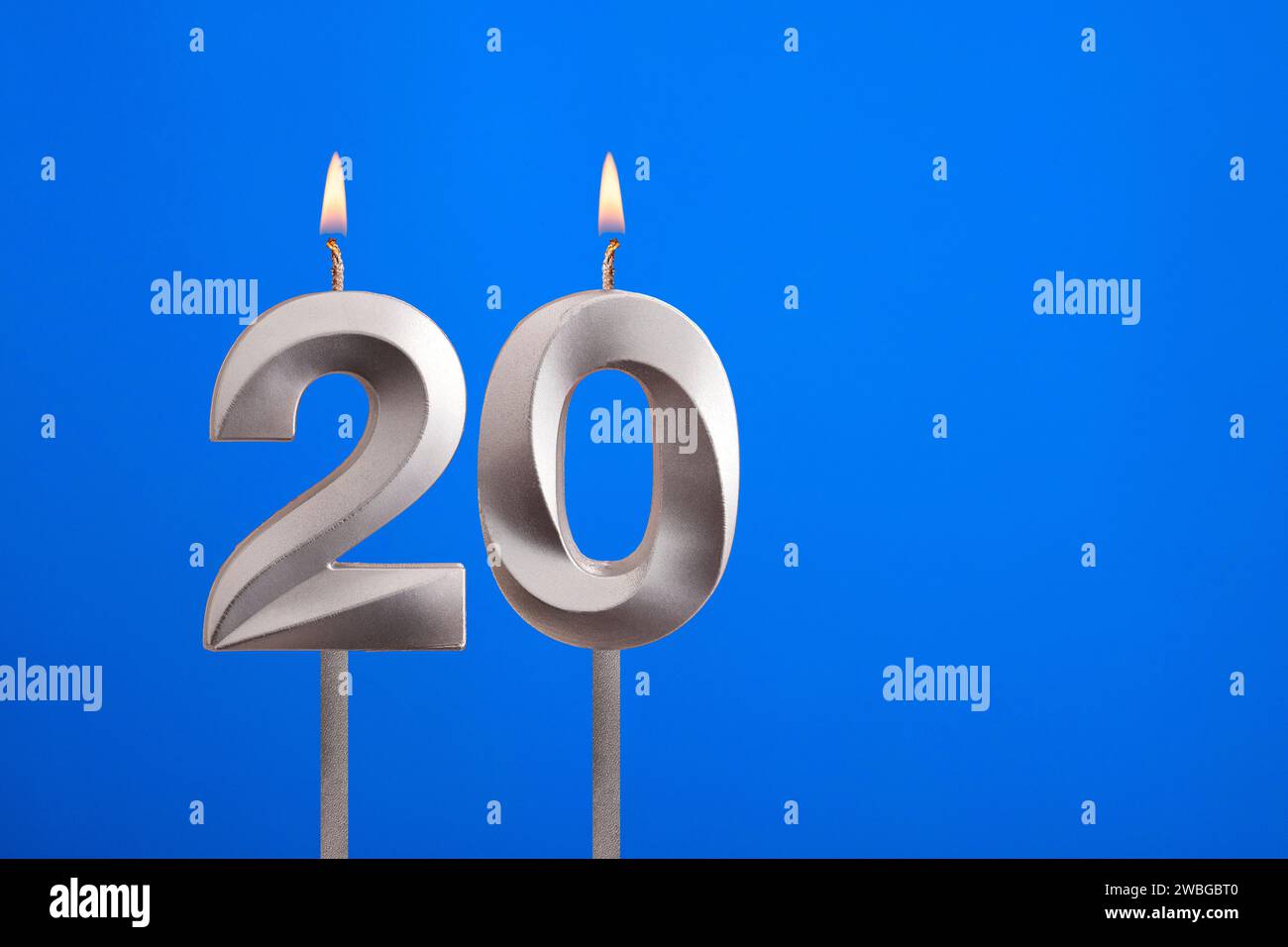 Birthday number 20 - Candle lit on blue background Stock Photo - Alamy
