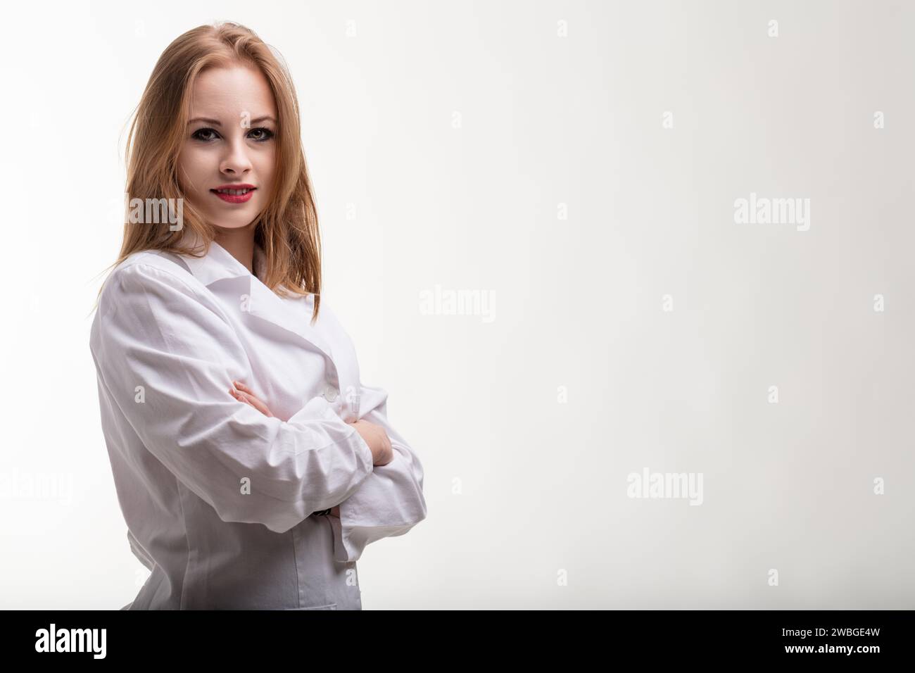Assertive woman with a subtle smile, arms folded, signifies readiness ...