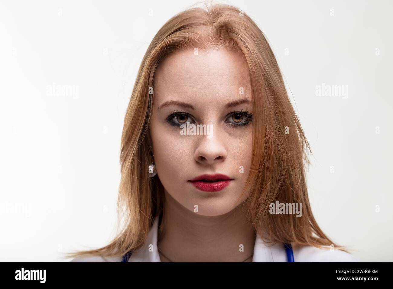 Confident medical practitioner dons a stethoscope, her direct look ...