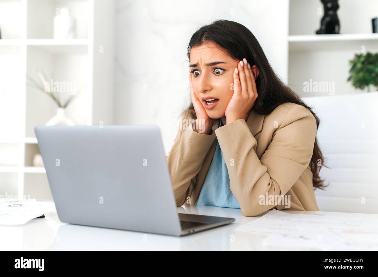 Shocked arabian or indian woman in elegant clothes, company employee, lawyer, ceo, sits at ...