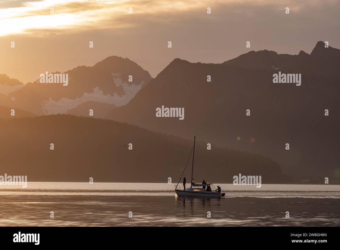 sailboat sails through calm waters beneath snow capped mounting in ...