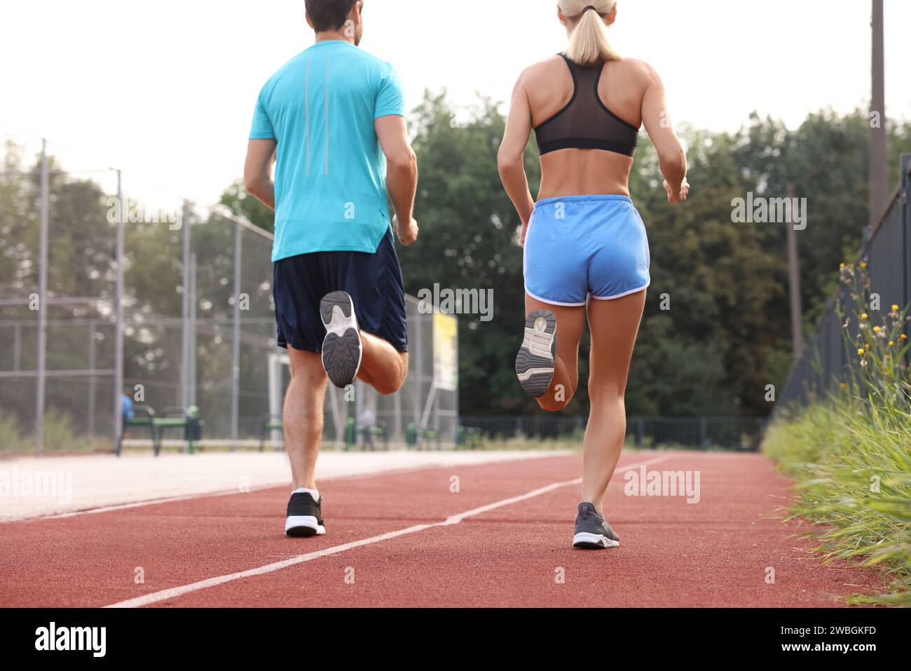 Healthy lifestyle. Sporty couple running at stadium, back view Stock ...