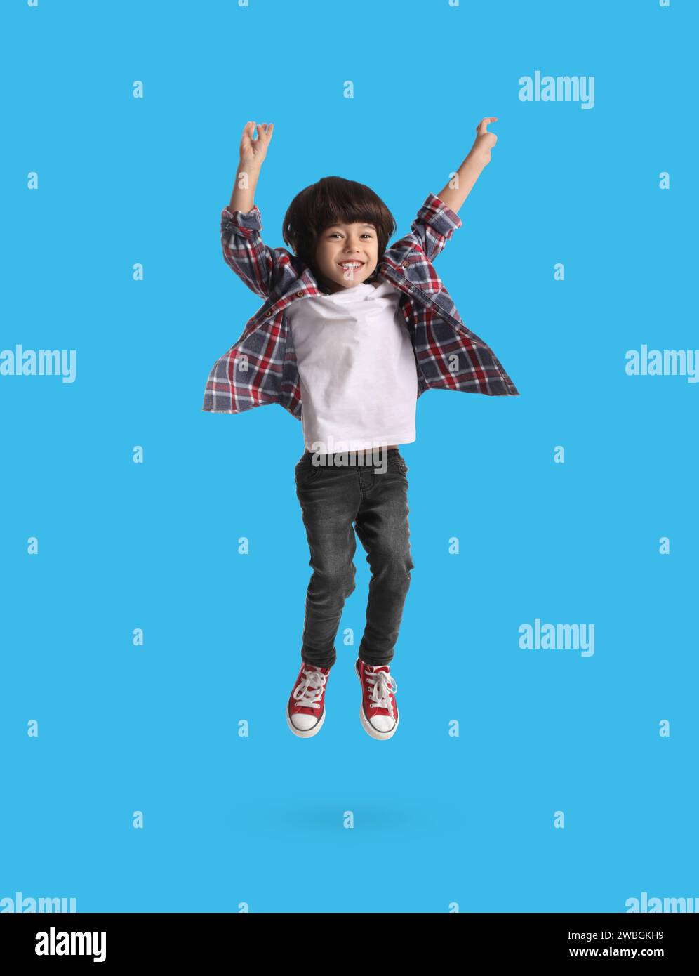Happy boy jumping on light blue background, full length portrait Stock ...