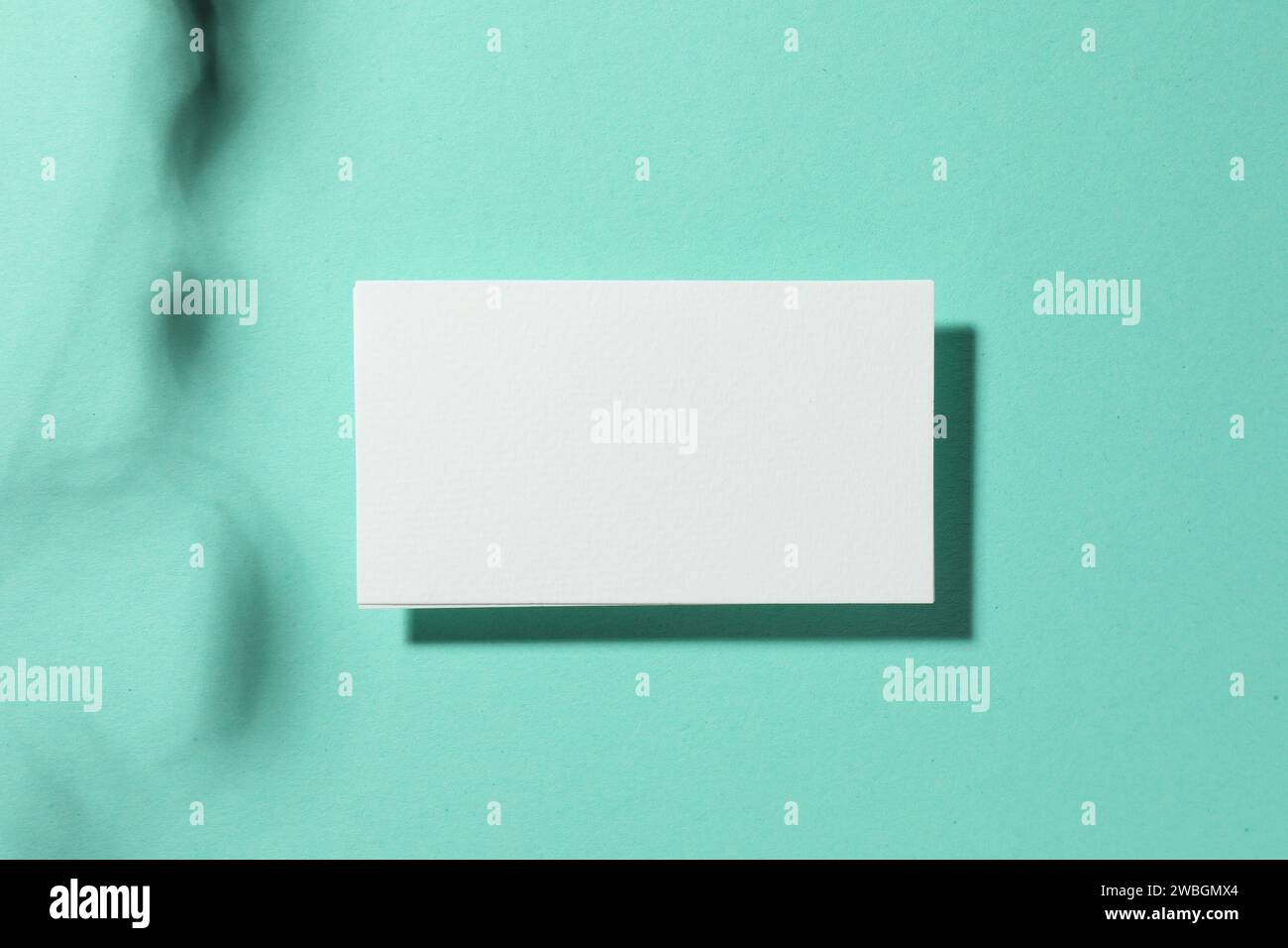 Empty business card on light blue background, top view. Mockup for ...