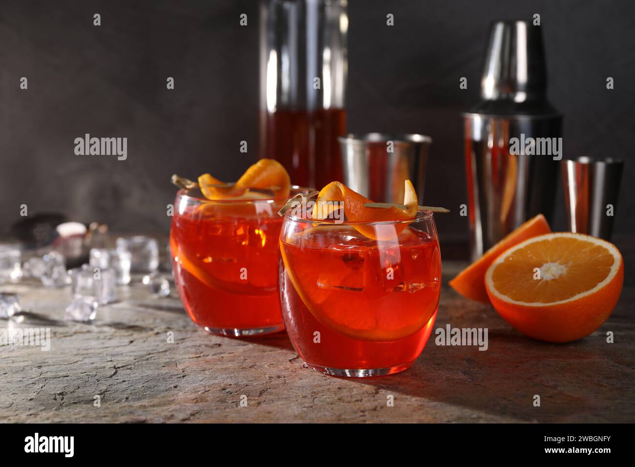 Aperol spritz cocktail, ice cubes and orange slices in glasses on grey ...