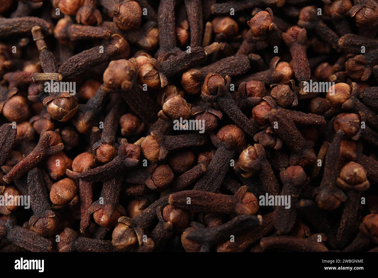 Many aromatic cloves as background, top view Stock Photo - Alamy