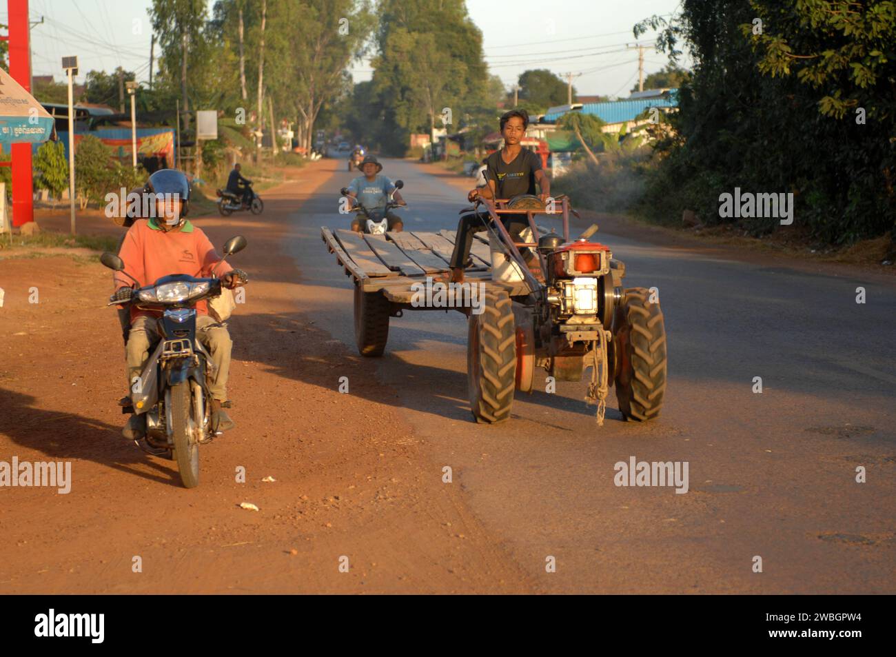Man driving a tractor down the high street, Beng Meala, Siem Reap ...