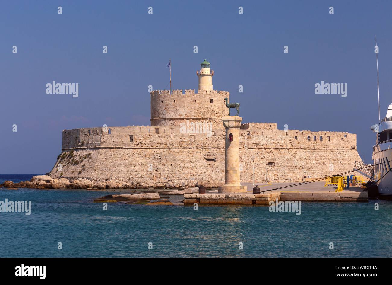 Scenic view of the sunlit old lighthouse against the blue sea in ...