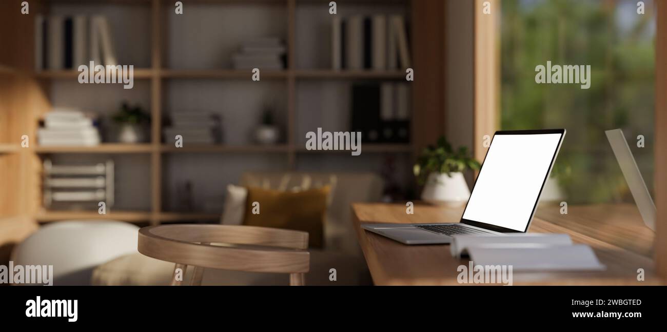 Side view image of a white-screen laptop computer on a wooden desk, a ...