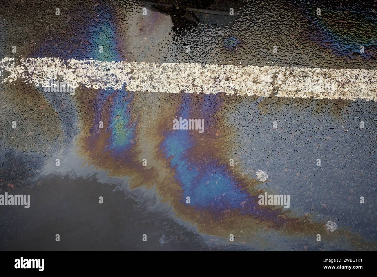 Oil spill on wet asphalt, parking lot with dividing line Stock Photo ...