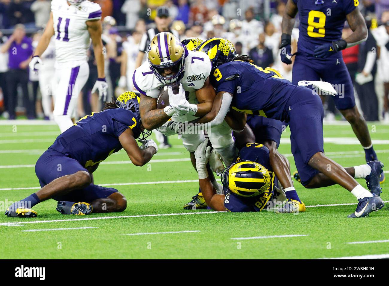 Houston, TX, USA. 8th Jan, 2024. Washington Huskies running back Dillon Johnson (7) is tackled ...
