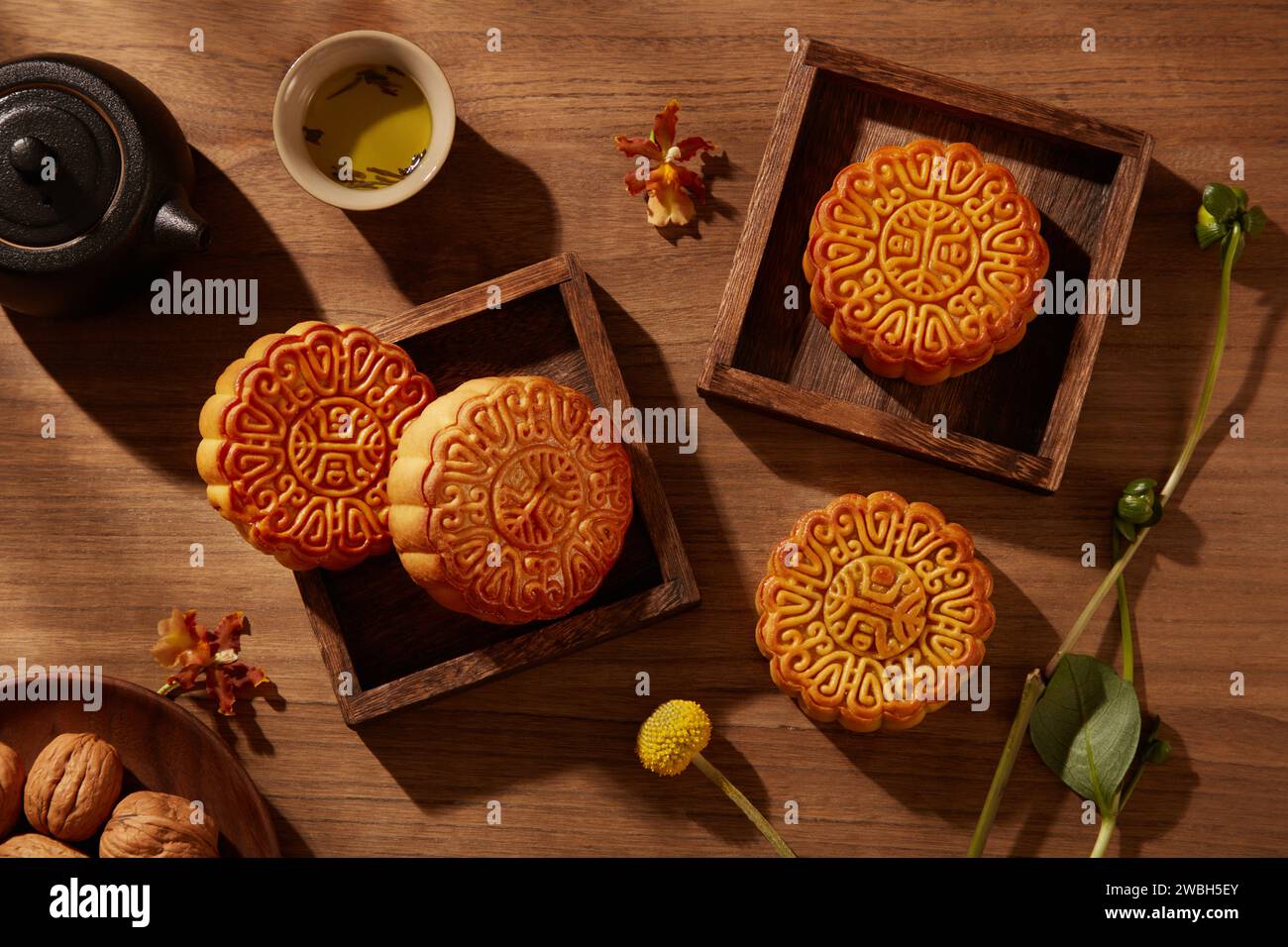 Baked mooncakes placed inside few wooden tray square-shaped. A dish of ...
