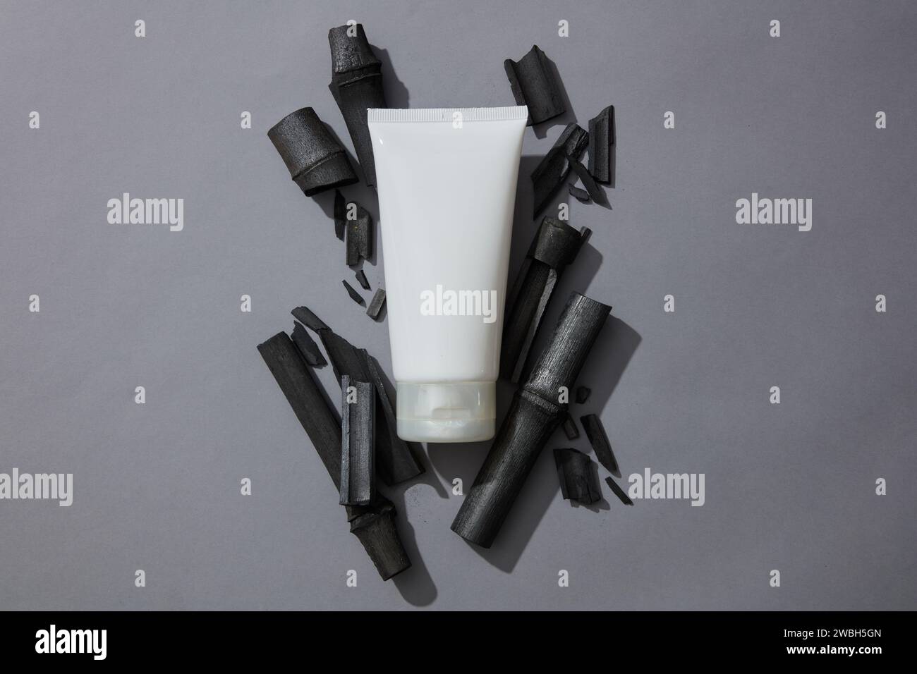 Empty label tube in white color placed on a pile of activated charcoal ...