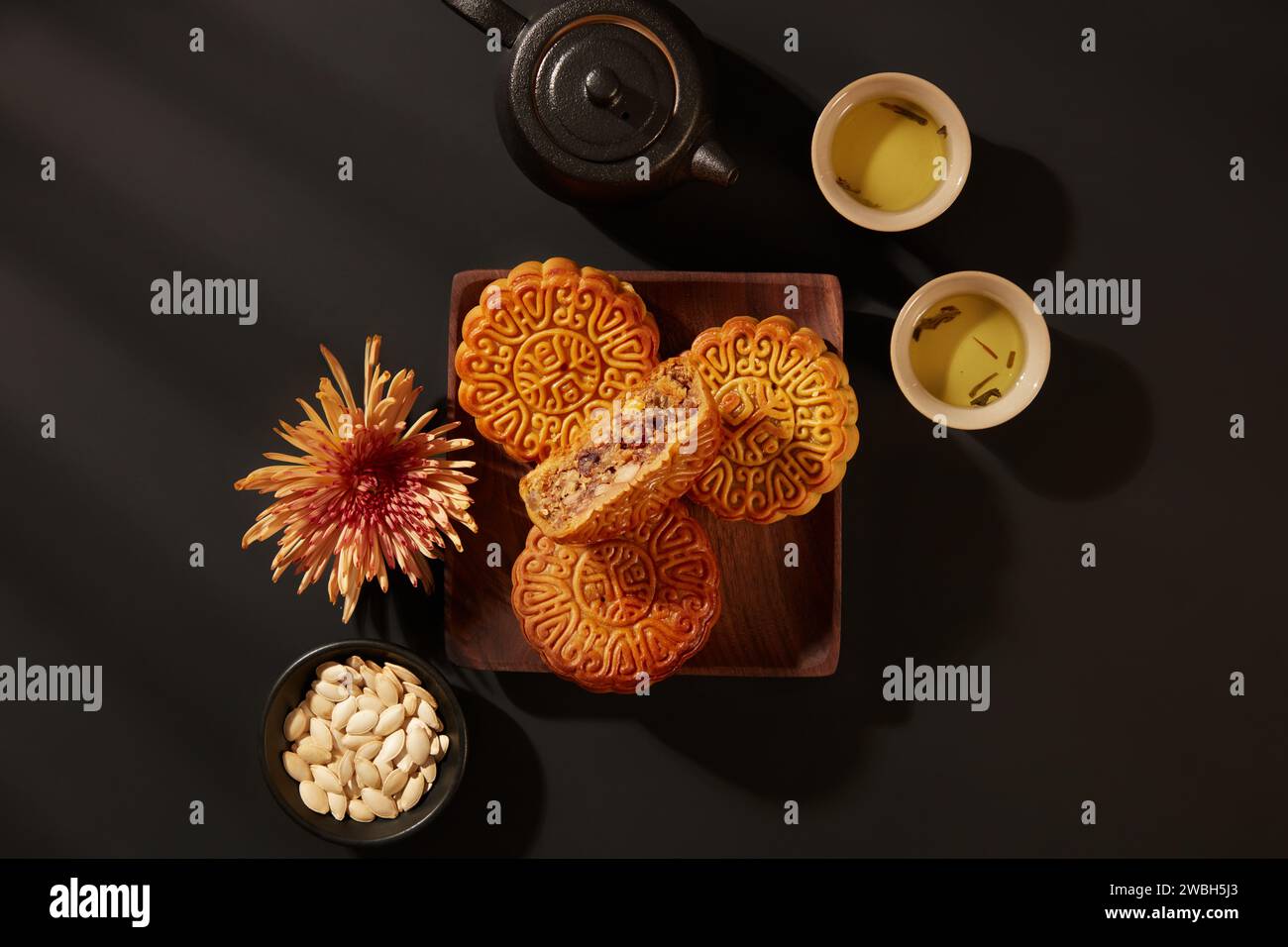 Mooncake cut in half with green rice and coconut filling. A small dish ...