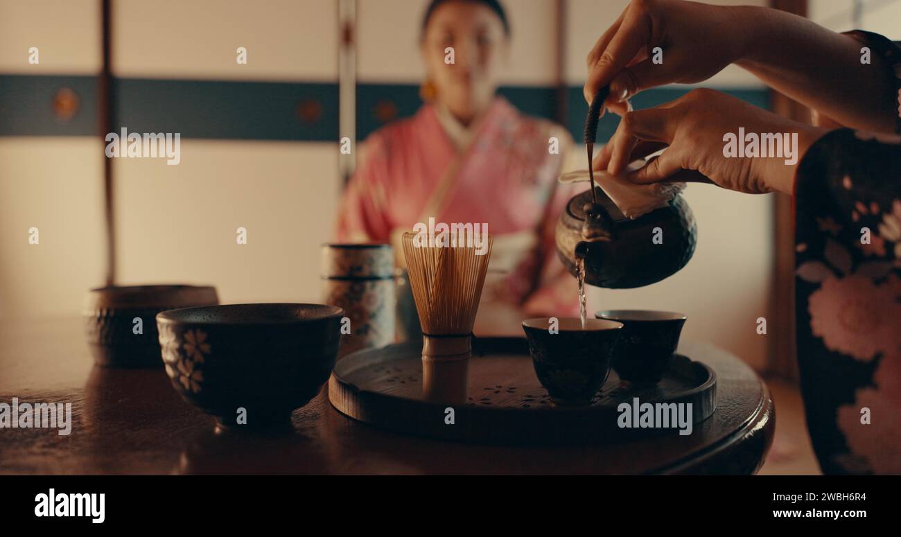 Woman pouring traditional Japanese tea with kimono, teapot and relax ...