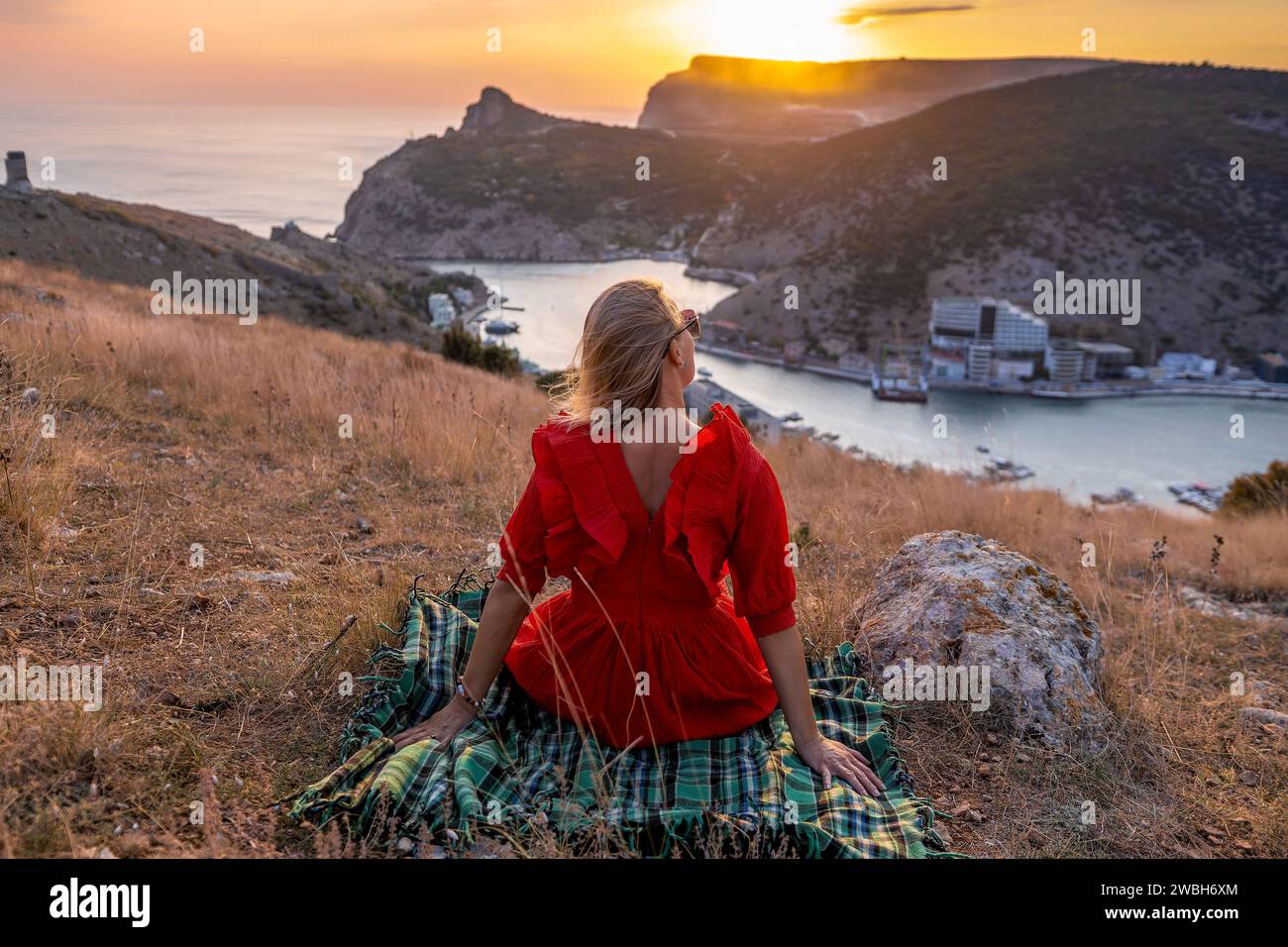 Woman sunset sea mountains. Happy woman siting with her back on the ...