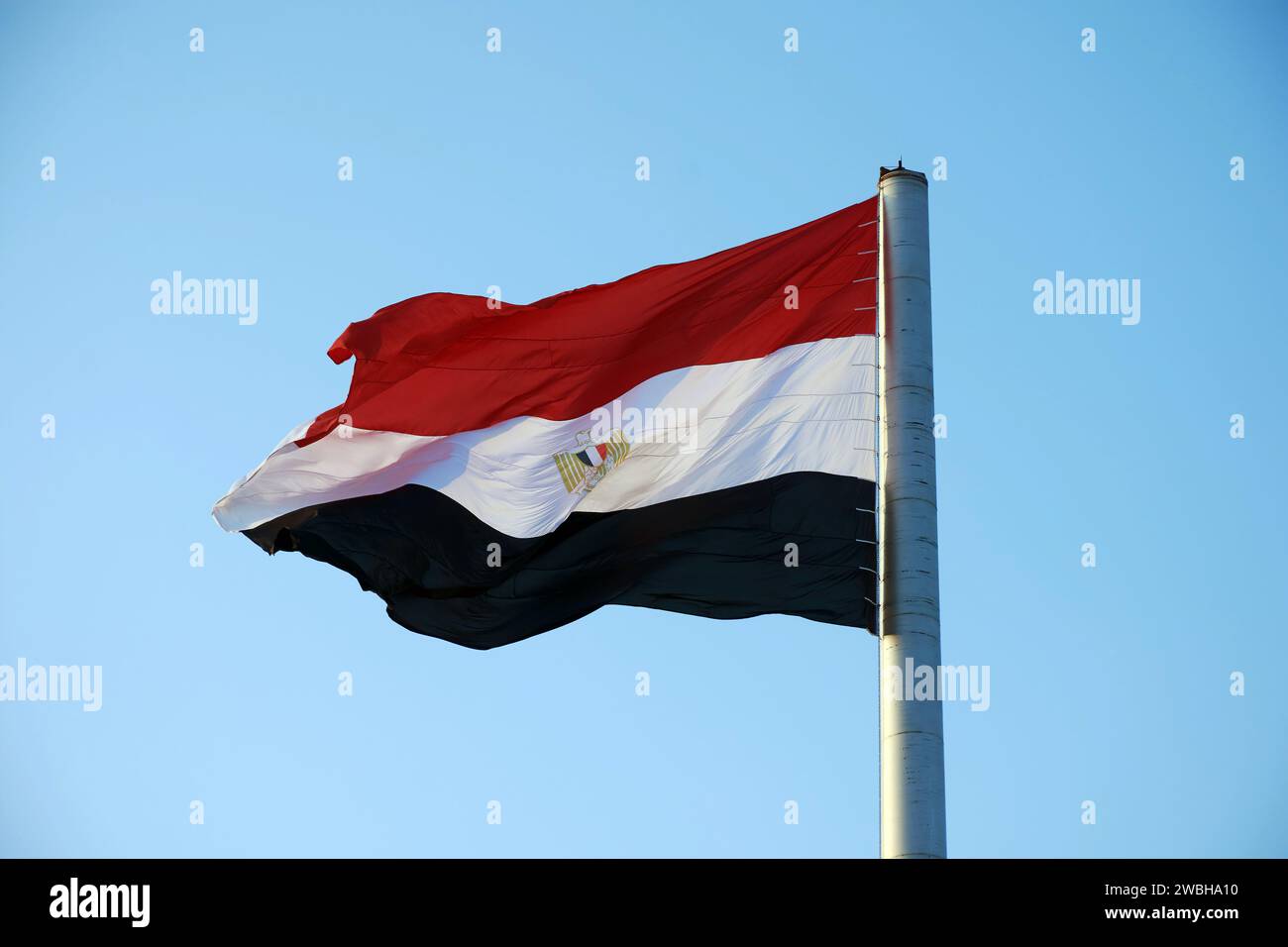 A large flag of Egypt on a flagpole against a blue sky Stock Photo - Alamy