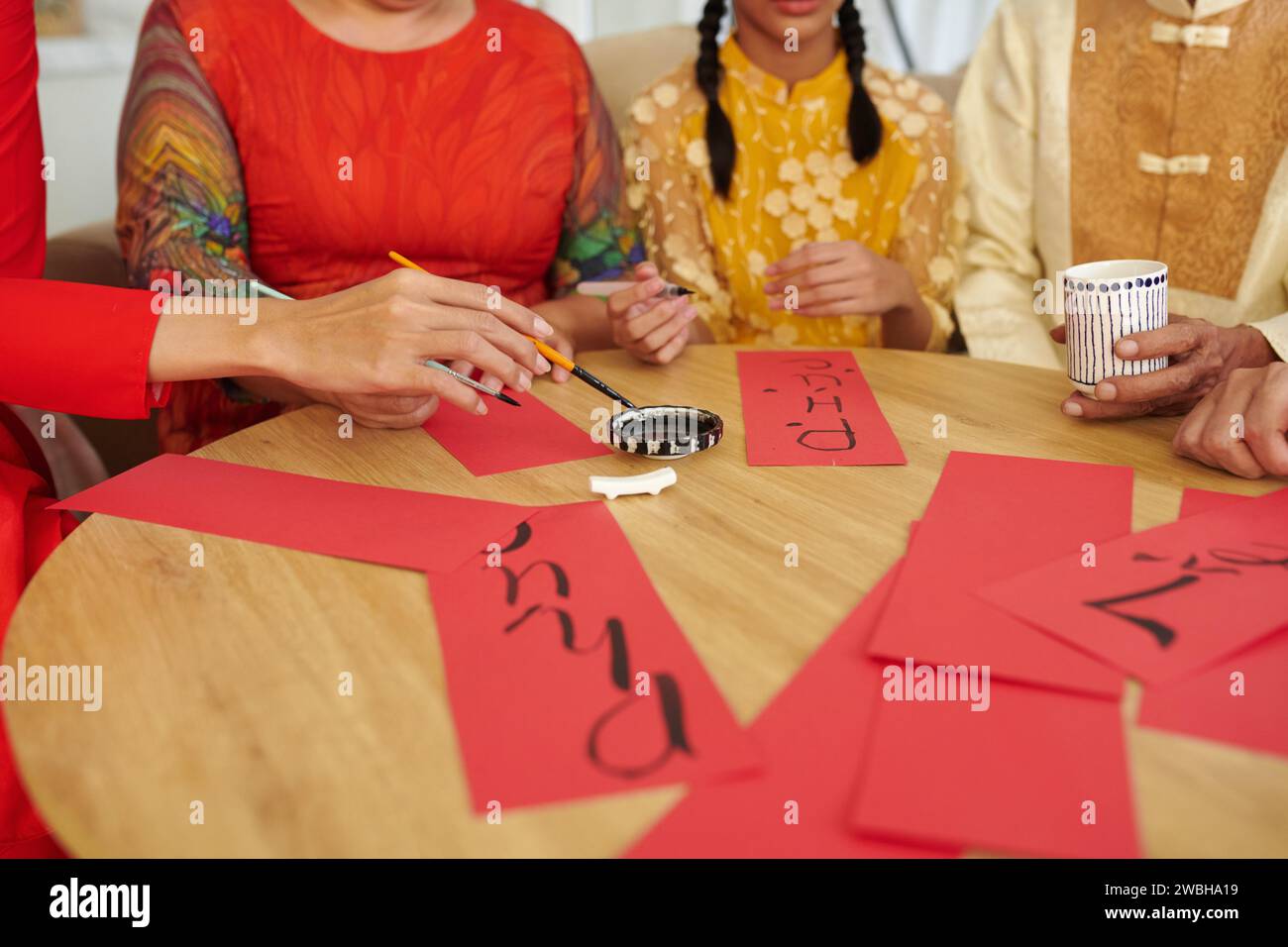 Hands of family members writing calligraphy couplets when preparing for ...