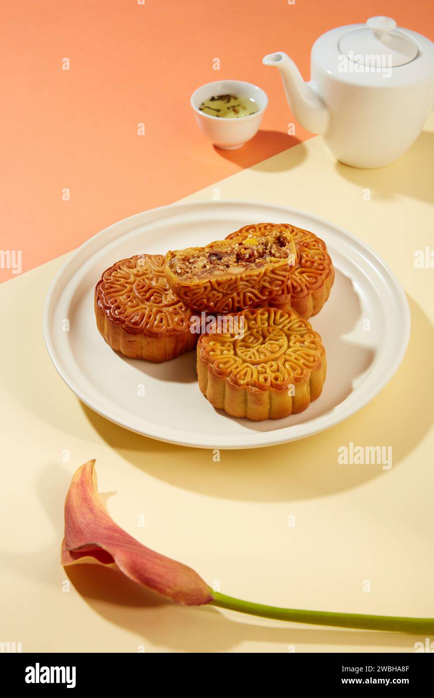 Few baked mooncakes placed on a white plate with a half of mooncake. A ...
