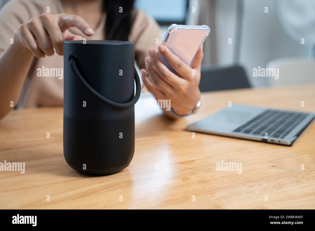 Young female operating smart speaker devices in her home through the ...