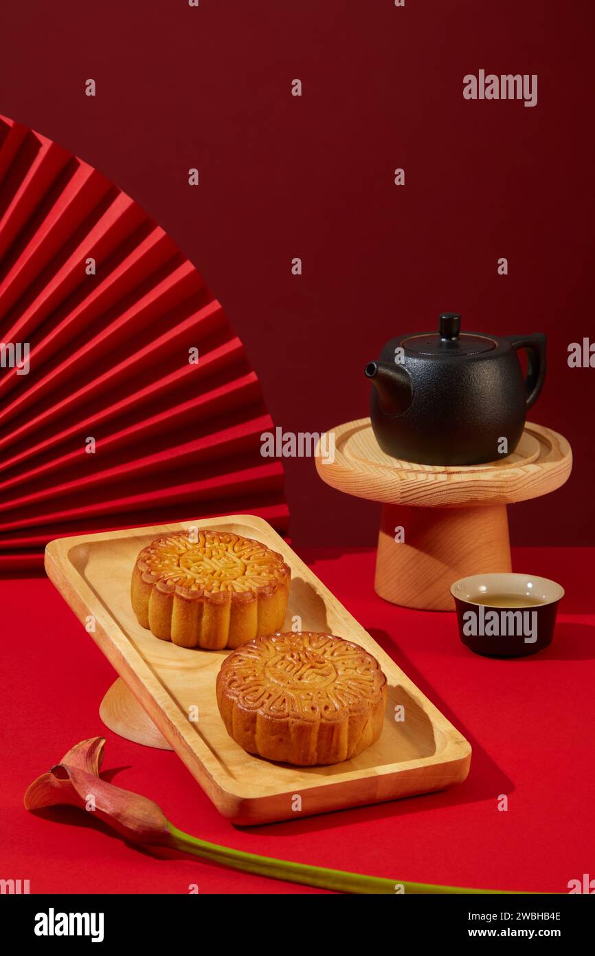 Baked mooncakes displayed on a rectangle wooden dish over red ...