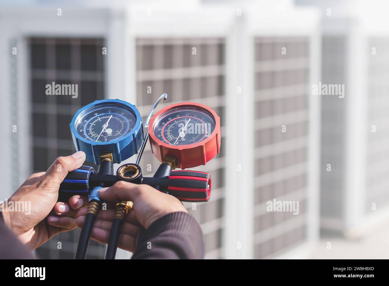 Air repair mechanic using measuring equipment for filling industrial ...