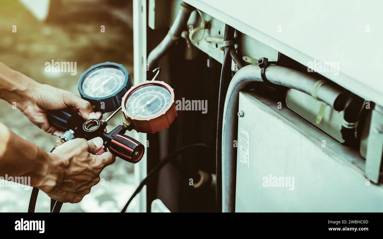 Air repair mechanic using measuring equipment for filling industrial ...