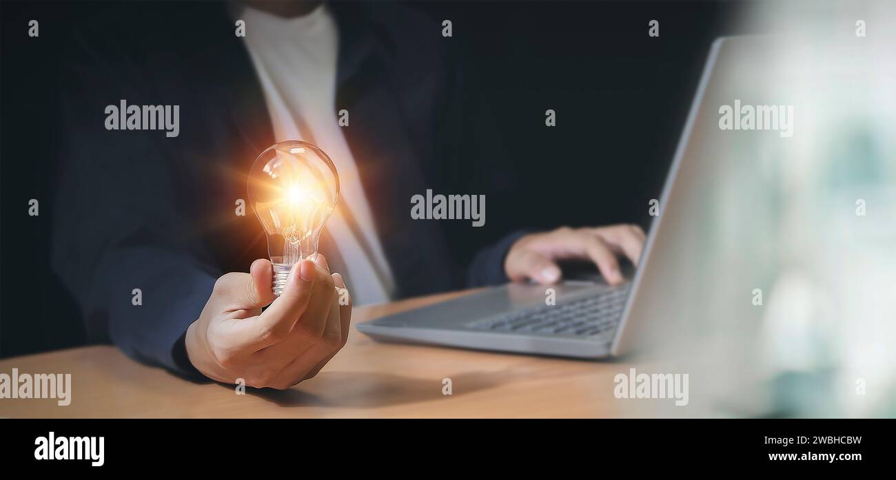 businessman holding an innovative light bulb creating new ideas inspirational ideas and problem ...