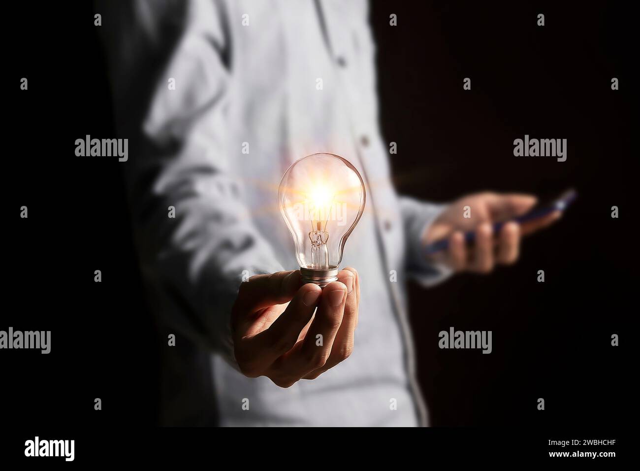 businessman holding an innovative light bulb creating new ideas inspirational ideas and problem ...