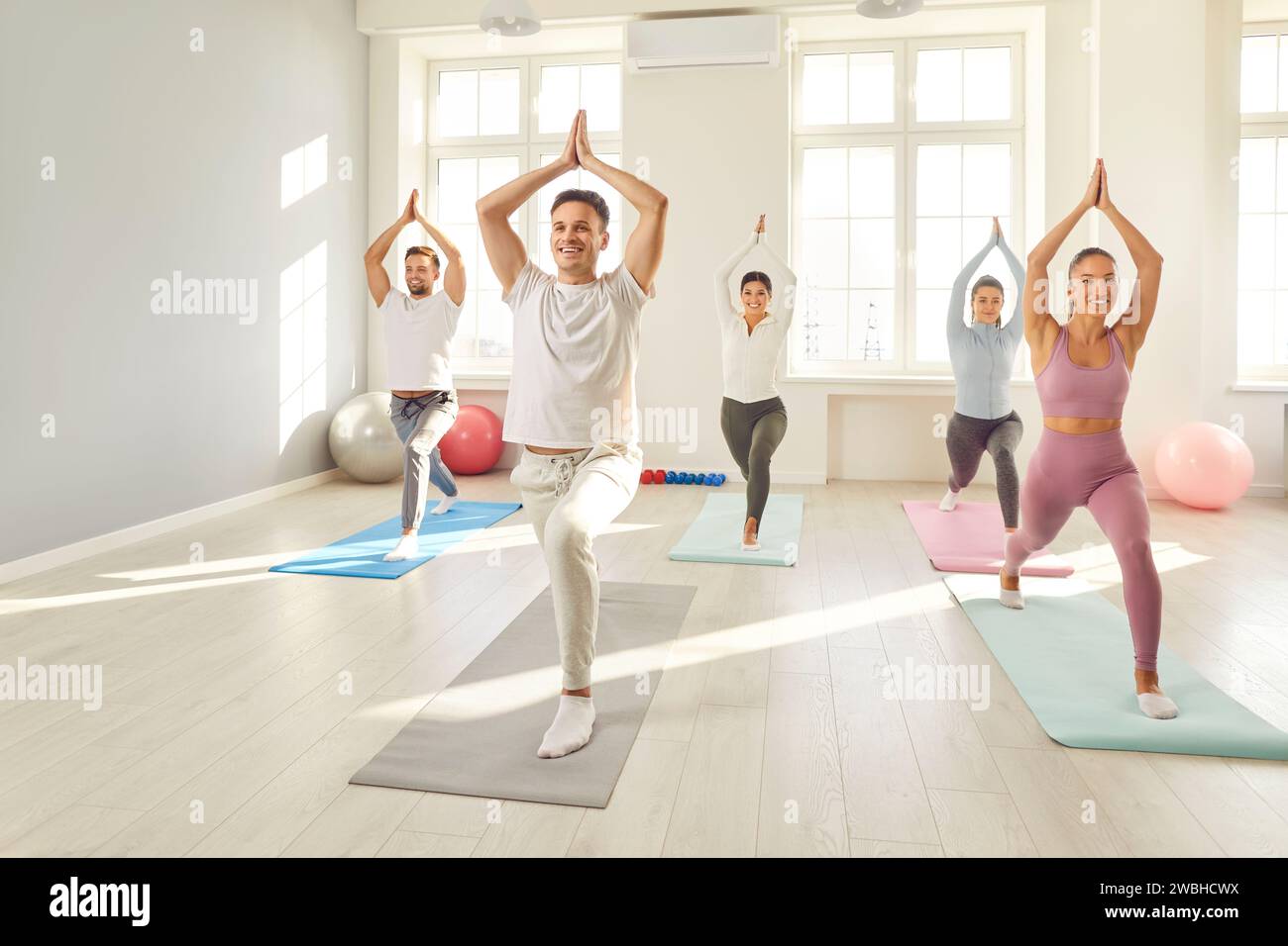 Joyful Group Yoga Session in the Gym Stock Photo - Alamy