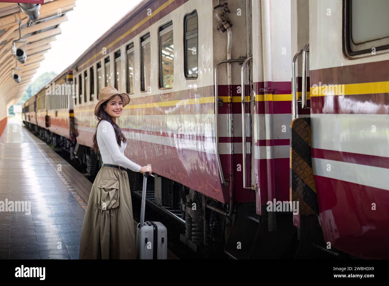 Alone Asian woman traveler with suitcase in train station platform ...