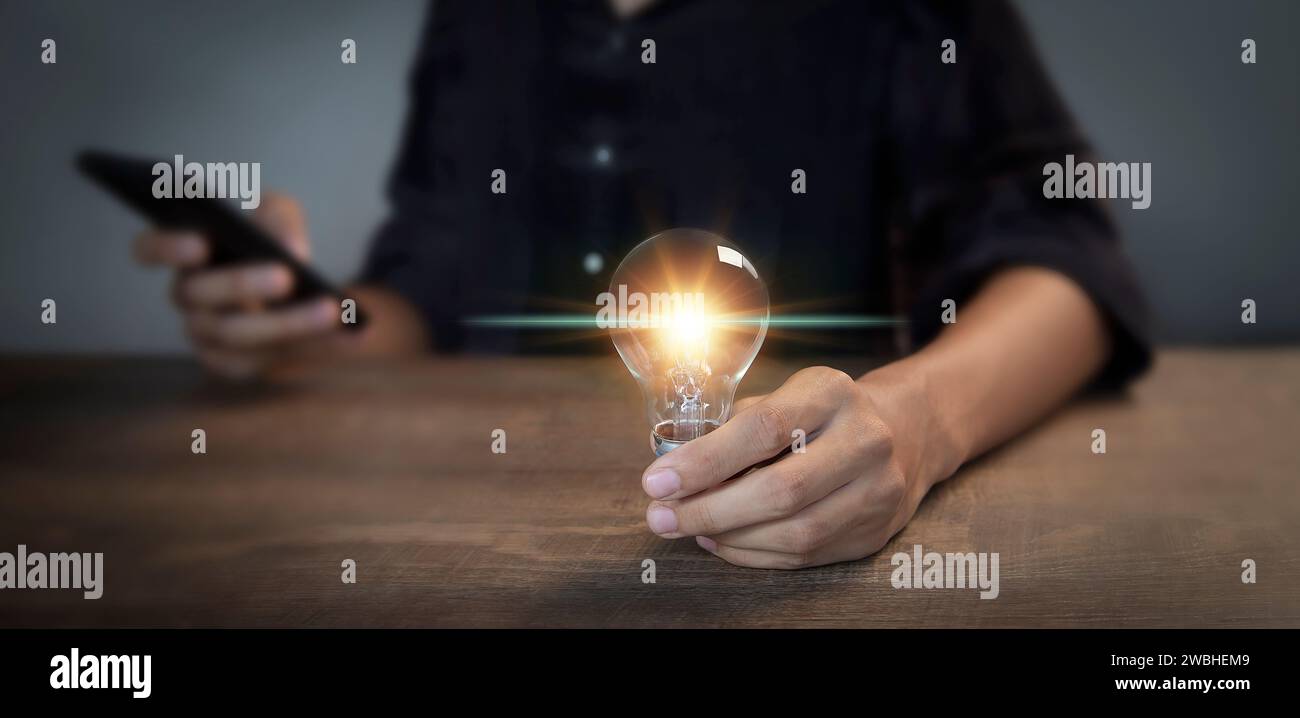 businessman holding an innovative light bulb creating new ideas inspirational ideas and problem ...