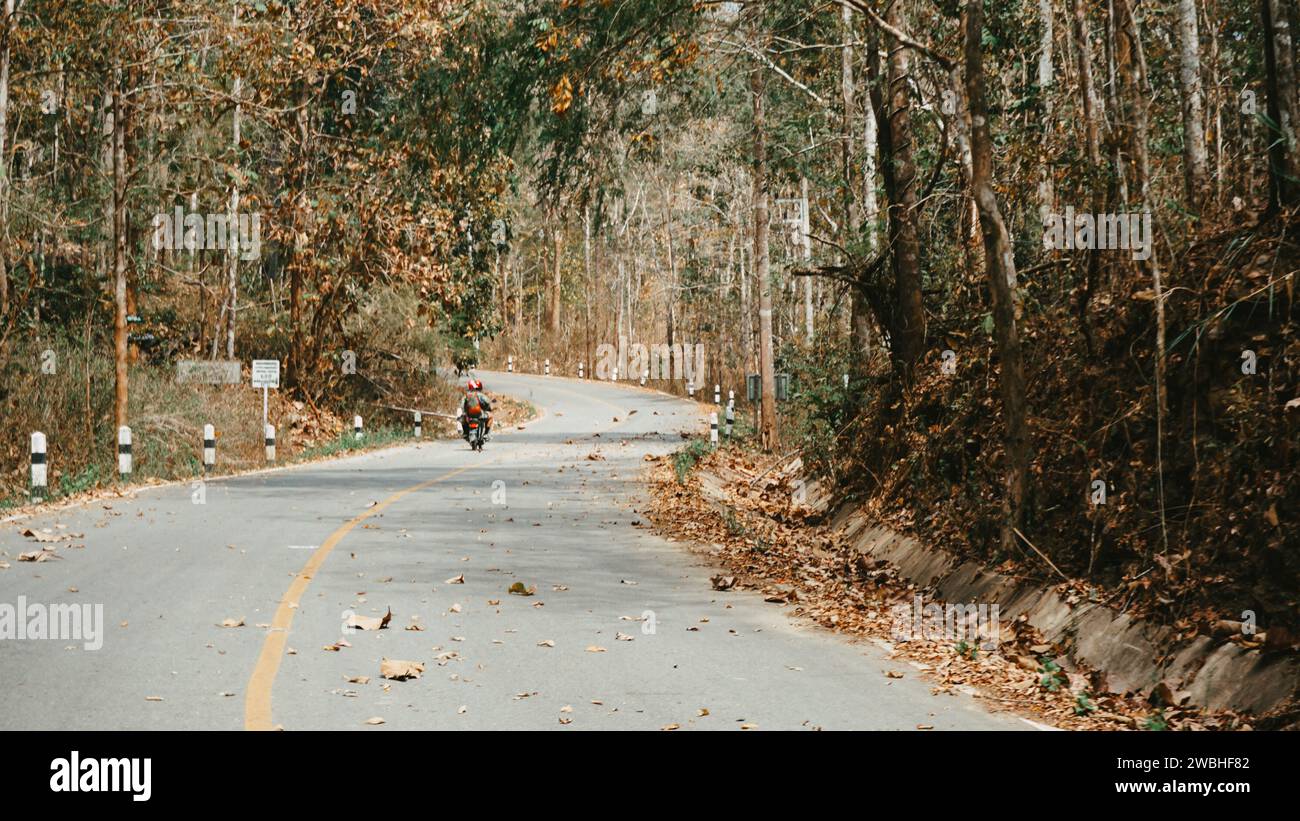 Biker is riding a motorcycle on the road ascending to the top of the ...