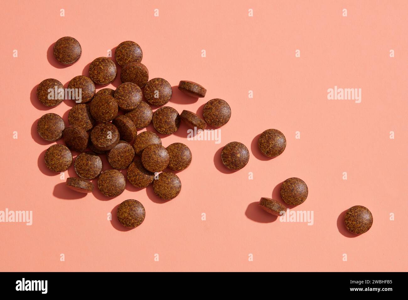 Green capsule of herbal medicine health supplement displayed on a pink ...