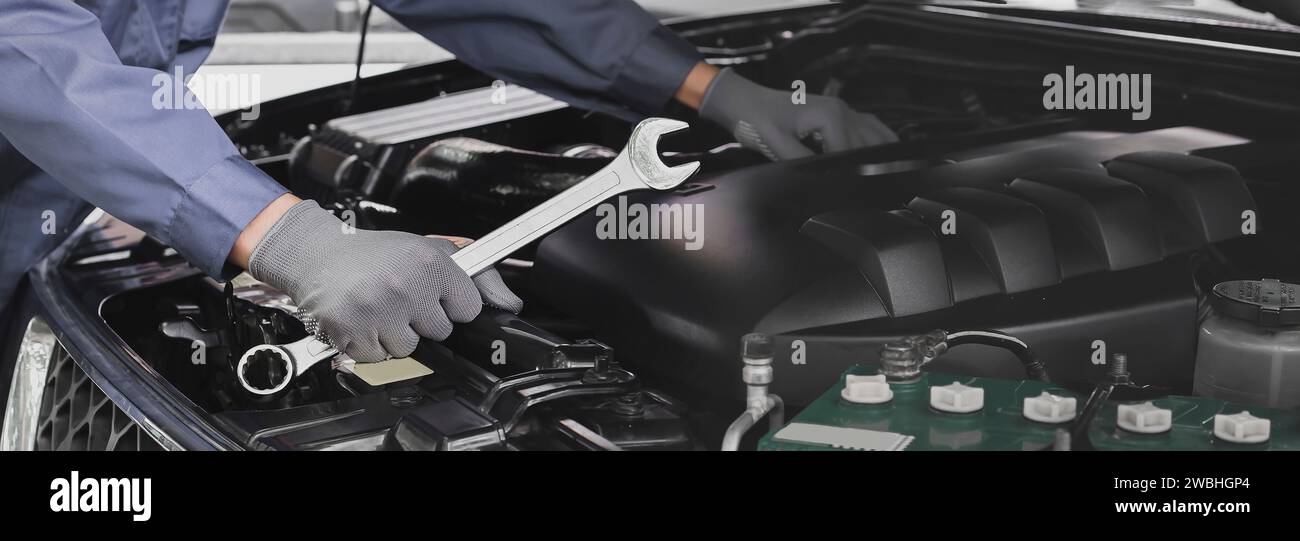 Mechanic works on the engine of the car in the garage.Concept of car ...