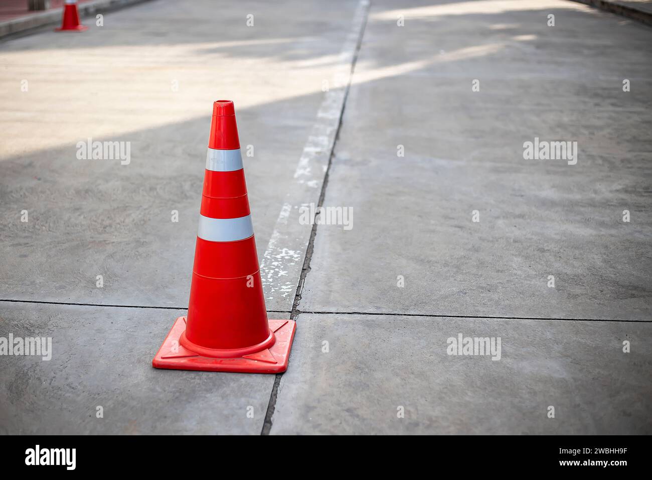 Orange traffic cones on concrete road Stock Photo - Alamy