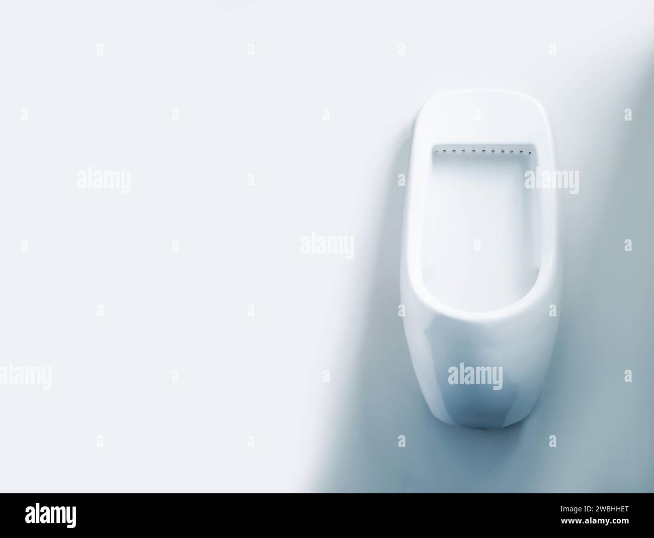 White urinals in men's restroom on white wall Stock Photo - Alamy
