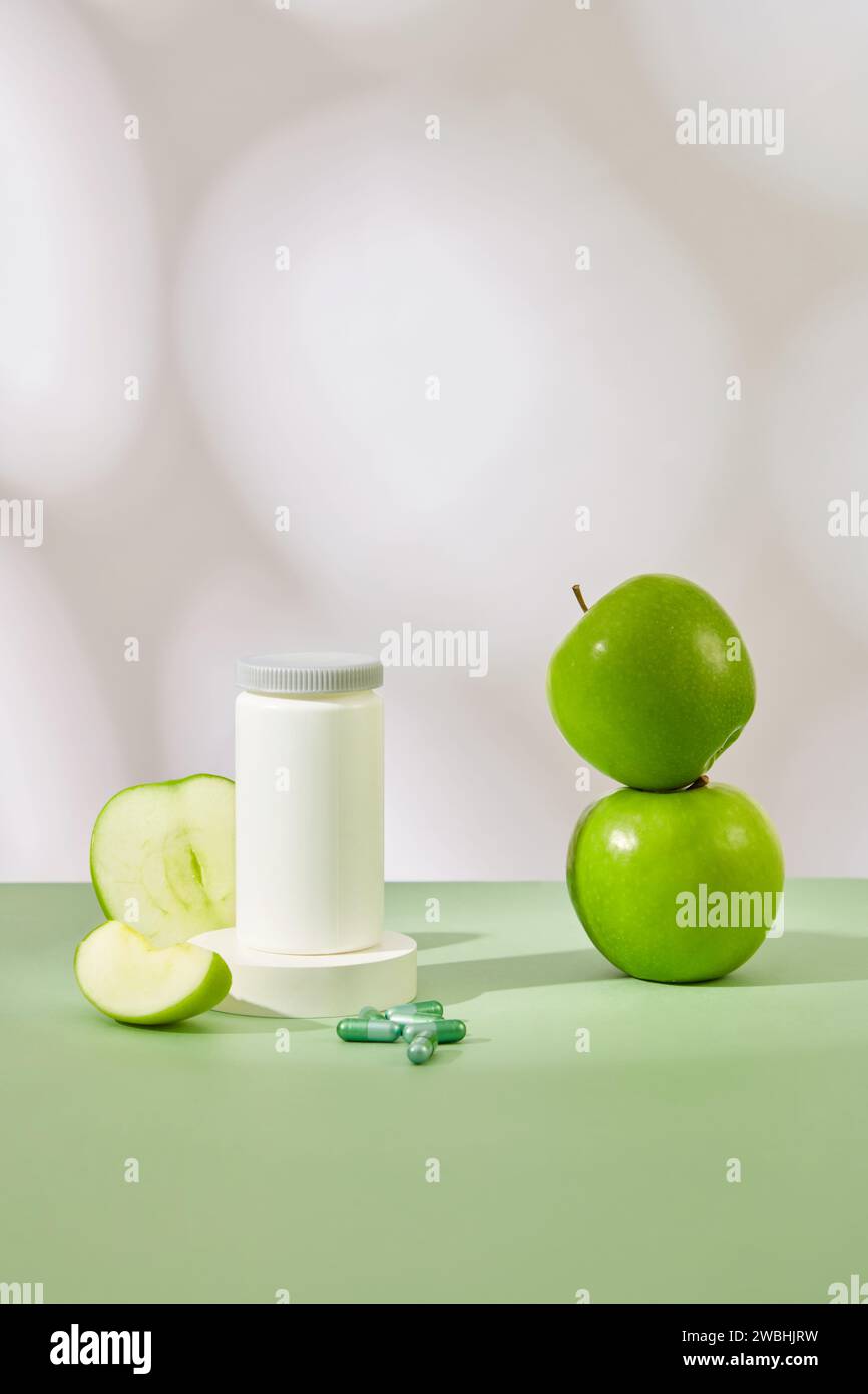 Unbranded bottle placed on round podium and a handful of capsules ...
