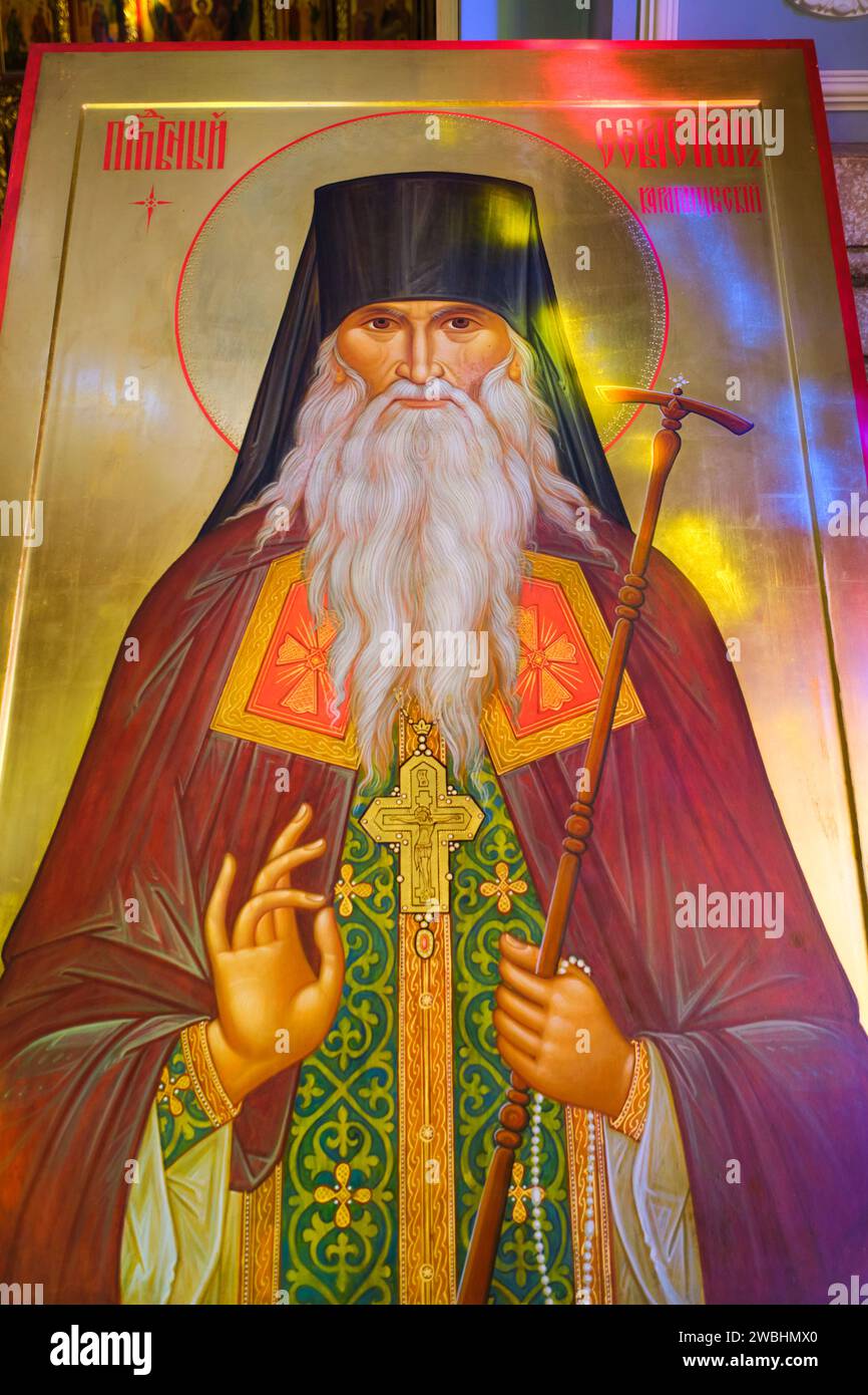 A wood panel, gold, memorial icon painting of an old priest with long ...