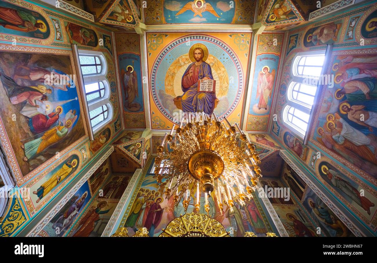 Interior soaring view of the large Christ painting on the domed ceiling and large chandelier. At ...