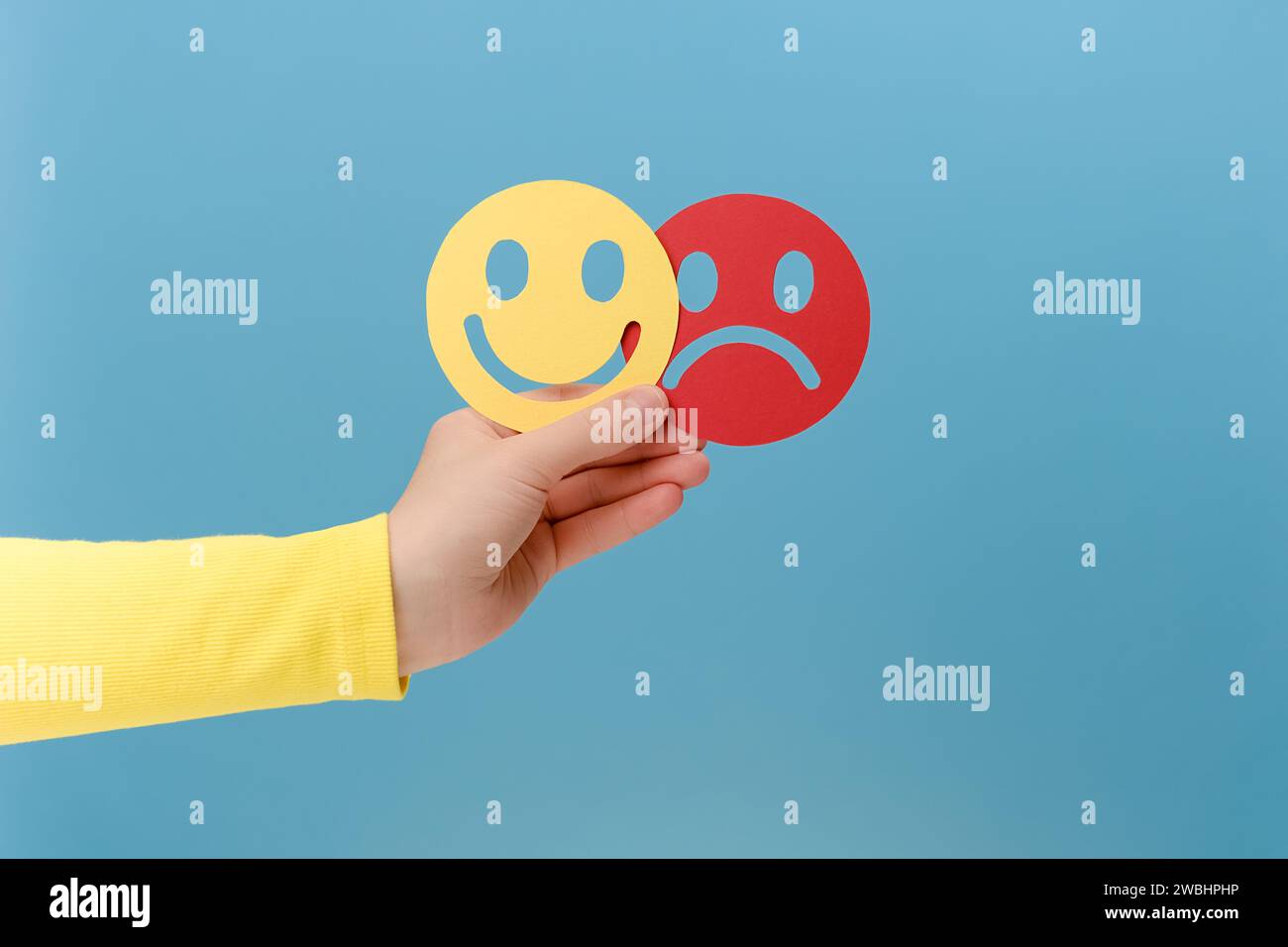 Close up of female hand holding happy and angry face paper, isolated on ...